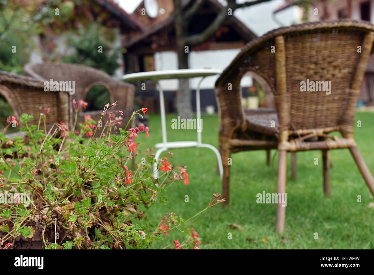 Rattan chairs and white table in a garden. Smoking area Stock Photo - Alamy