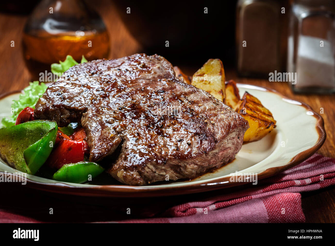 Portions of grilled beef steak served with grilled potatoes and paprika ...