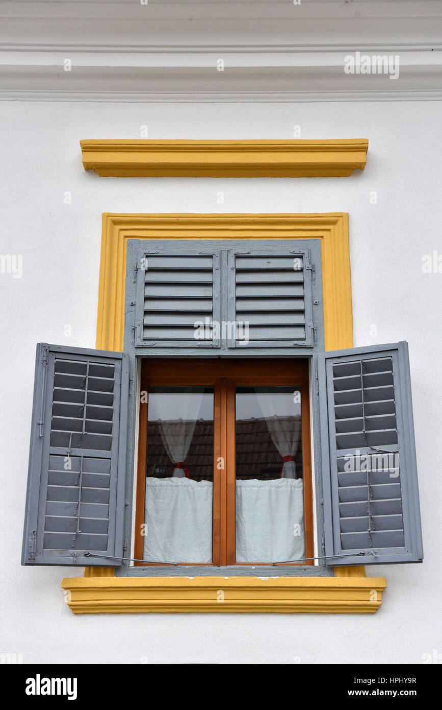 Classic yellow and gray wooden window shutters on a rural house Stock ...