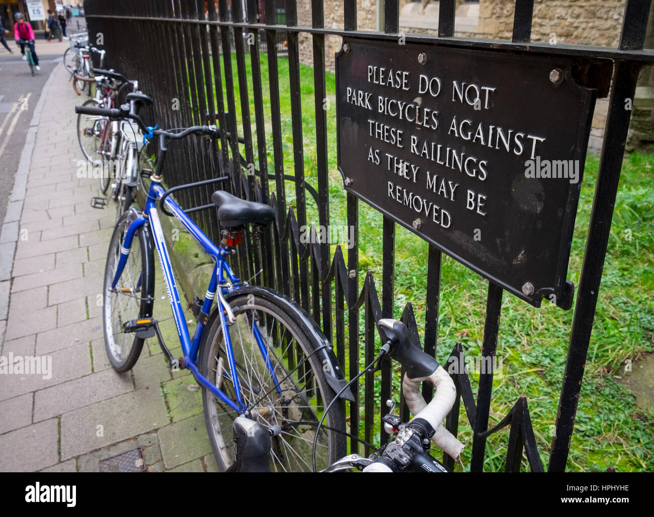 Bicycles locked to a railing under a Do Not Park Bicycles against ...