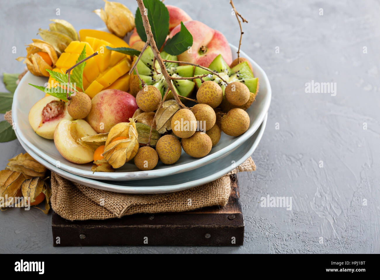 Tropical fruit plate with mango, apricots, longan and kiwi Stock Photo ...