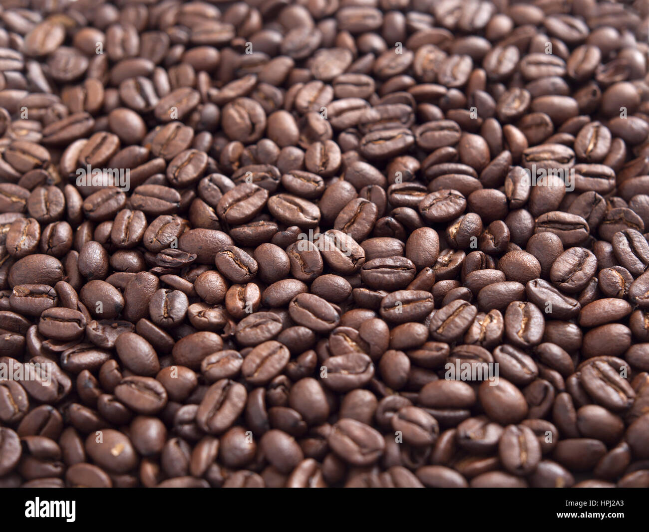 Organic, fresh roasted coffee beans spread out on a flat surface Stock ...
