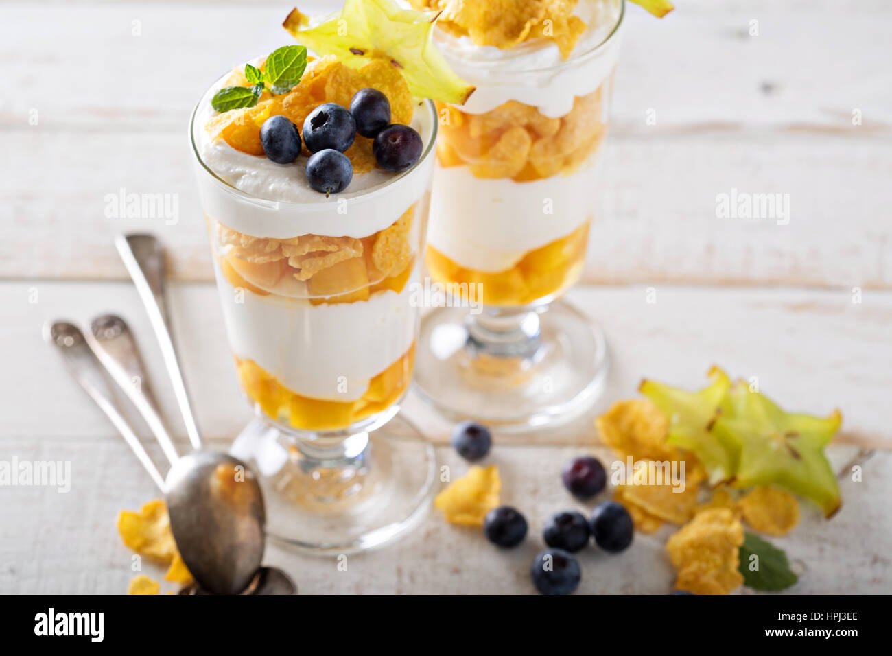Yogurt cereal parfait with mango and tropical fruits, layered dessert ...