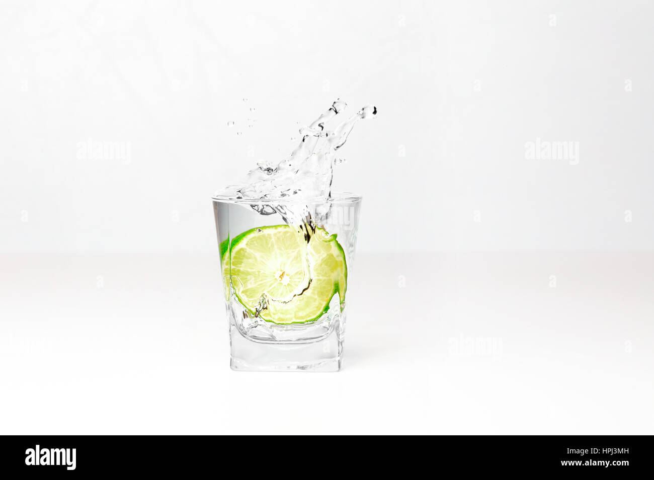 Lime is falling in the glass isolated on white background Stock Photo ...