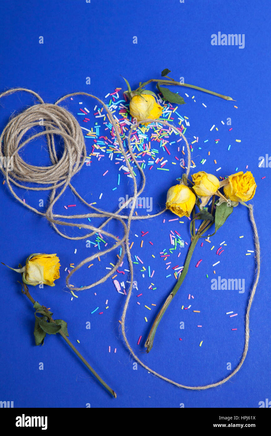 The roses with rope and sprinkles for cake at blue background Stock ...