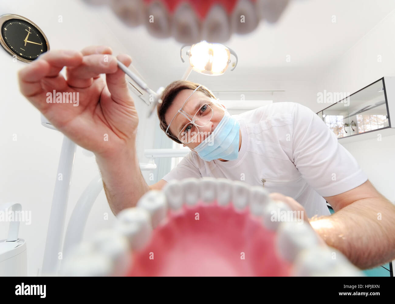 Stomatology. Dentist over open patient's mouth looking in teeth. Inside ...