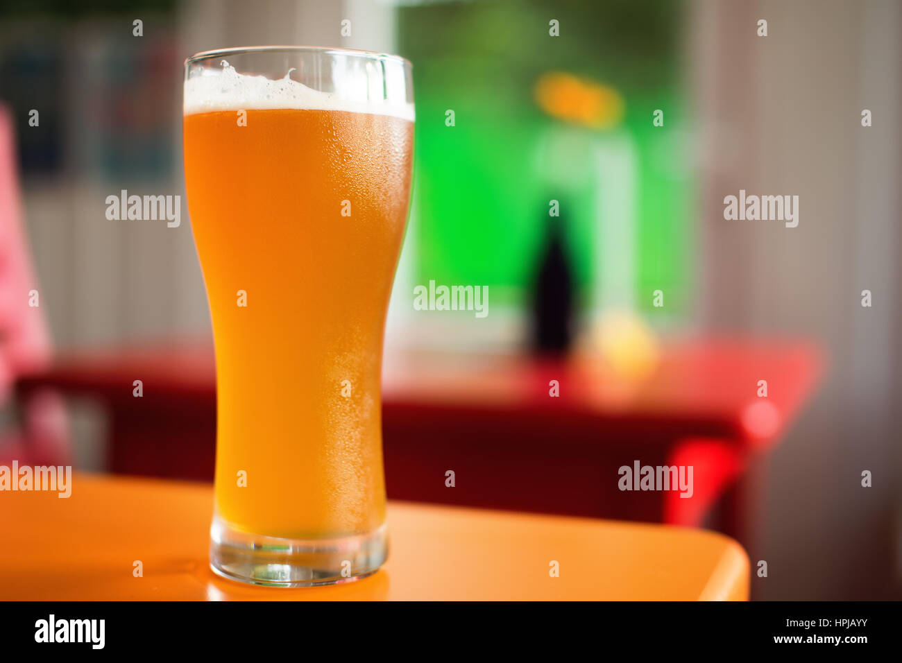 Pint of golden ale tapped craft beer on table in colorful bar. Vivid ...
