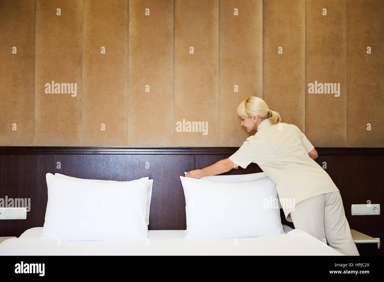 Hotel service. Made making bed in room Stock Photo - Alamy