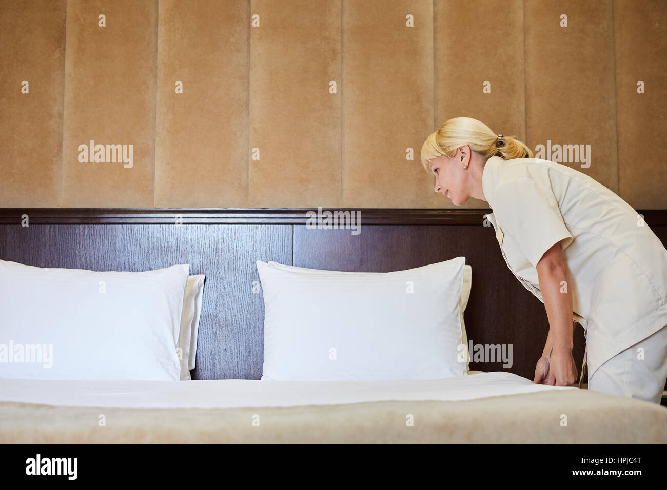 Hotel service. Made making bed in room Stock Photo - Alamy