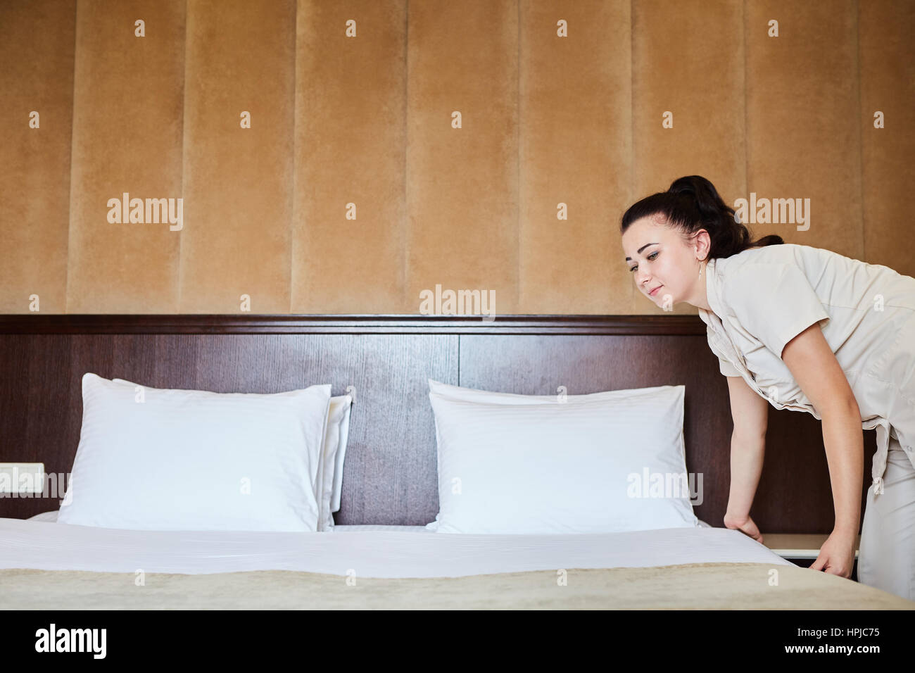 Hotel service. Made making bed in room Stock Photo - Alamy