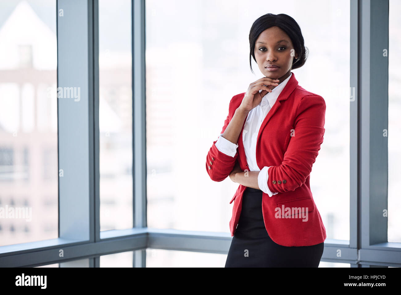 Confident businesswoman looking at the camera with bold body language ...