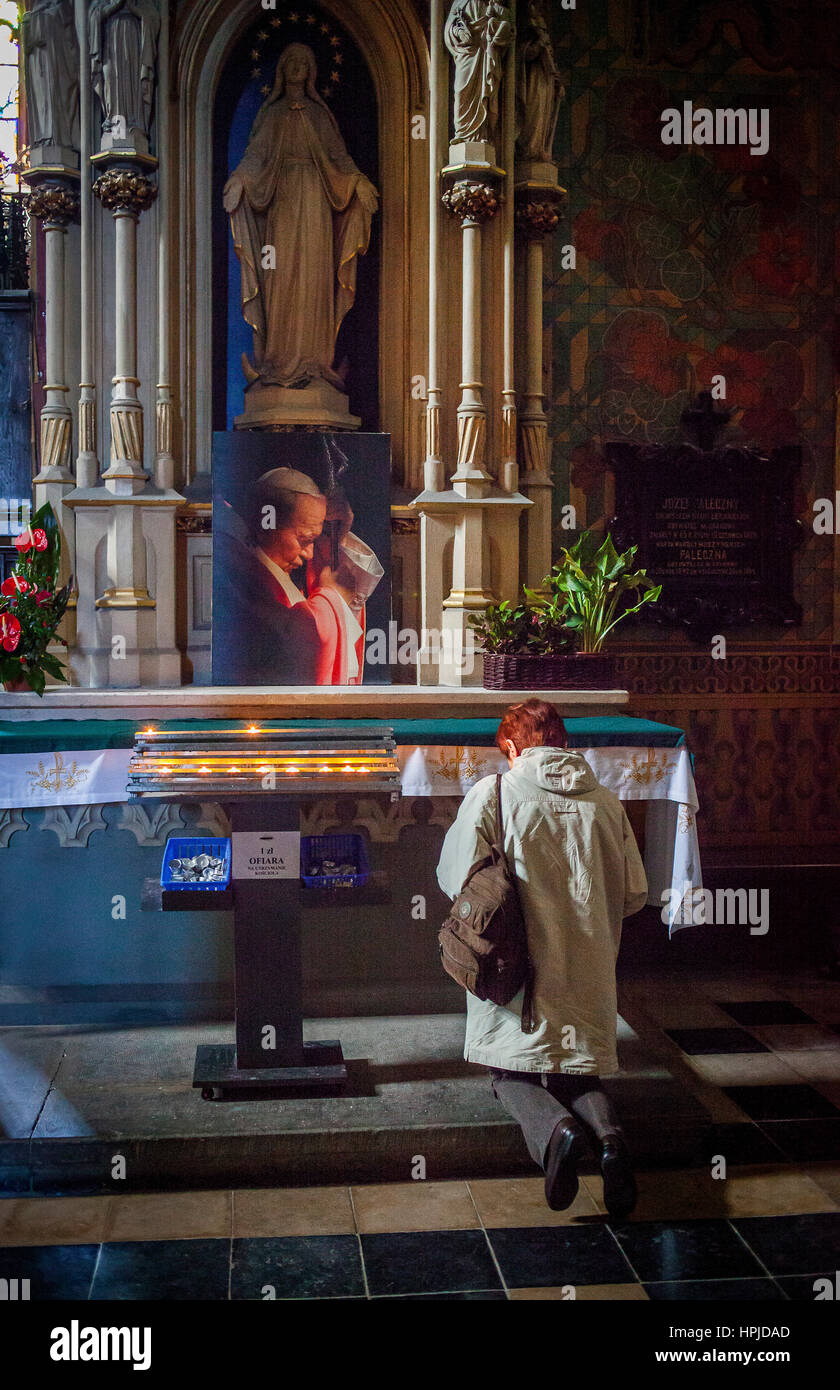 Woman praying in front of John Paul II portrait , Franciscan Church ...