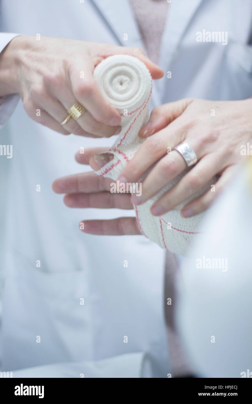 Doctor applying a plaster cast and bandages to patient forearm and ...