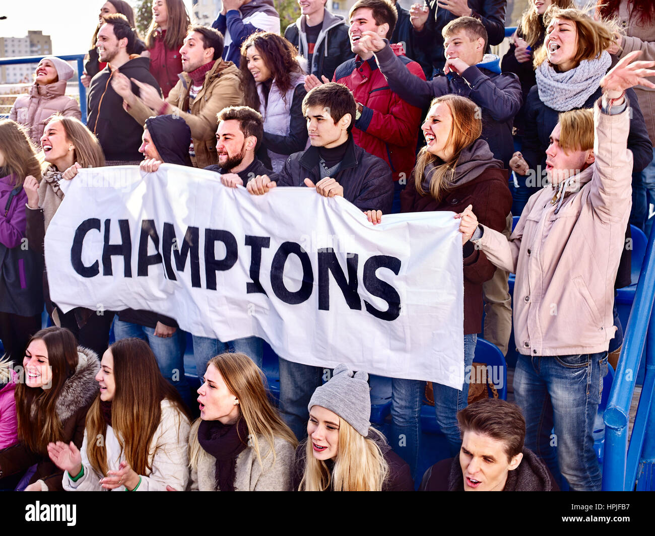 Cheering fans in stadium holding champion banner Stock Photo - Alamy