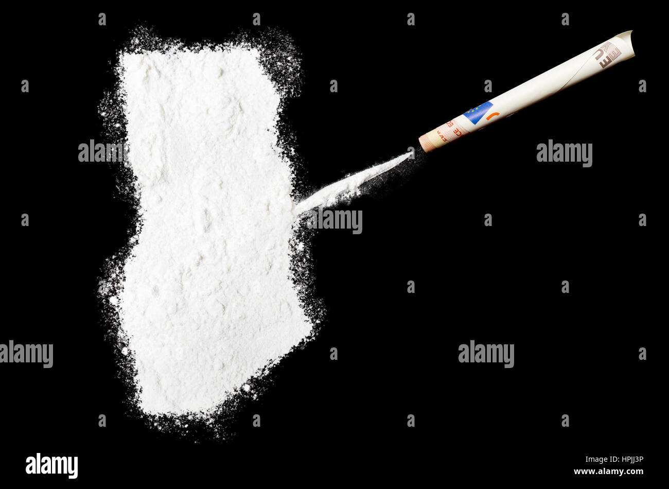 A powder drug like cocaine in the shape of Ghana with a rolled money ...