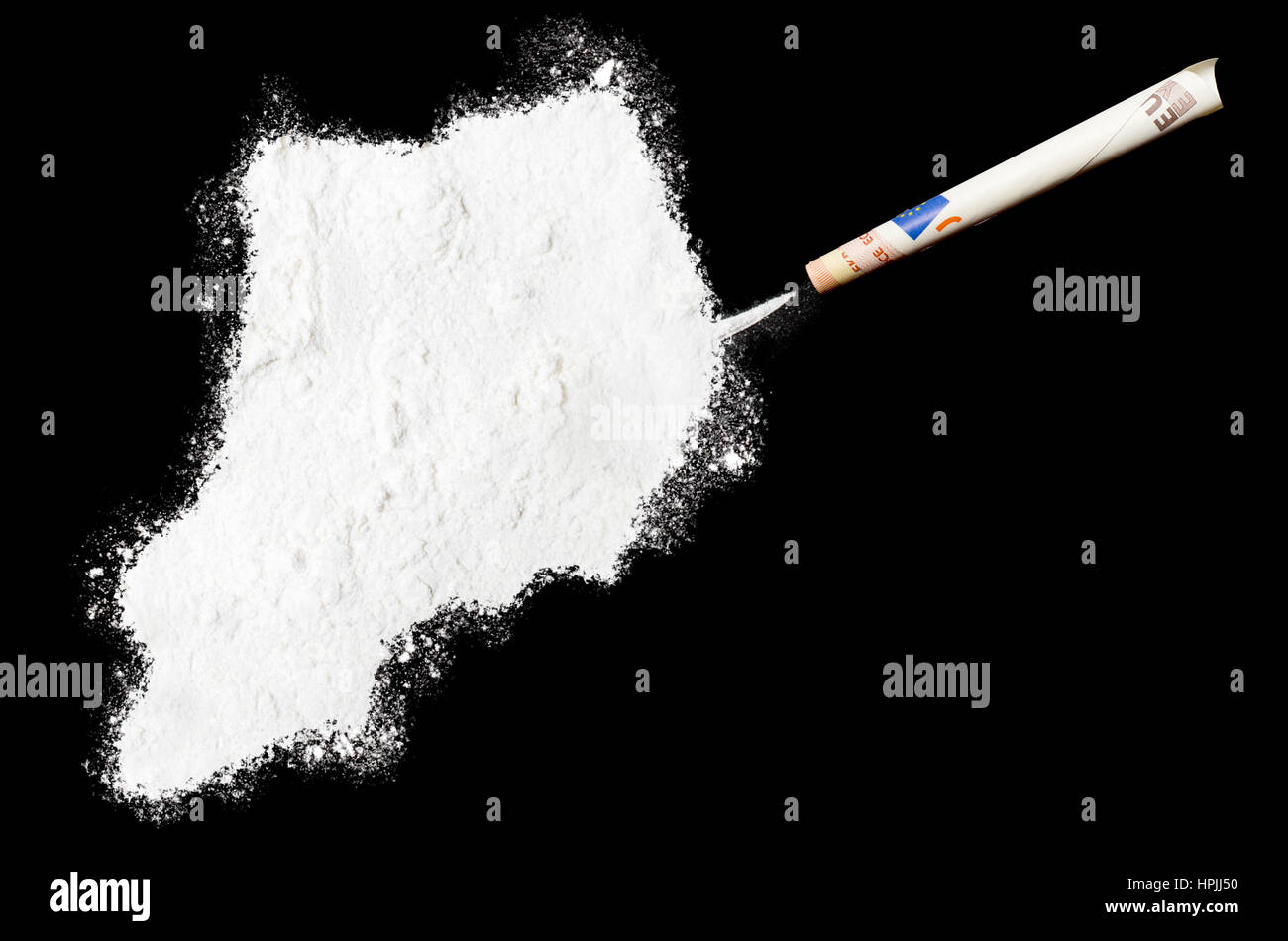 A powder drug like cocaine in the shape of Uganda with a rolled money ...