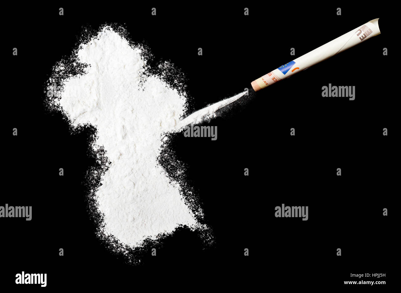 A powder drug like cocaine in the shape of Guyana with a rolled money ...