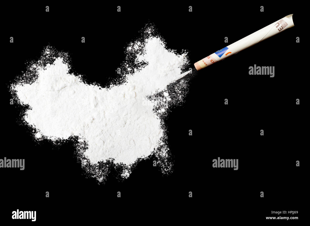 A powder drug like cocaine in the shape of China with a rolled money ...