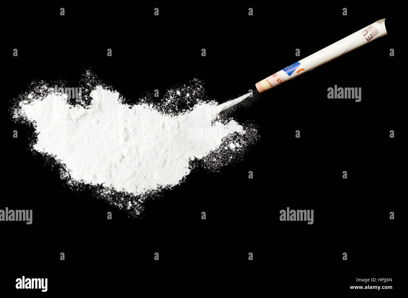 A powder drug like cocaine in the shape of Mongolia with a rolled money ...