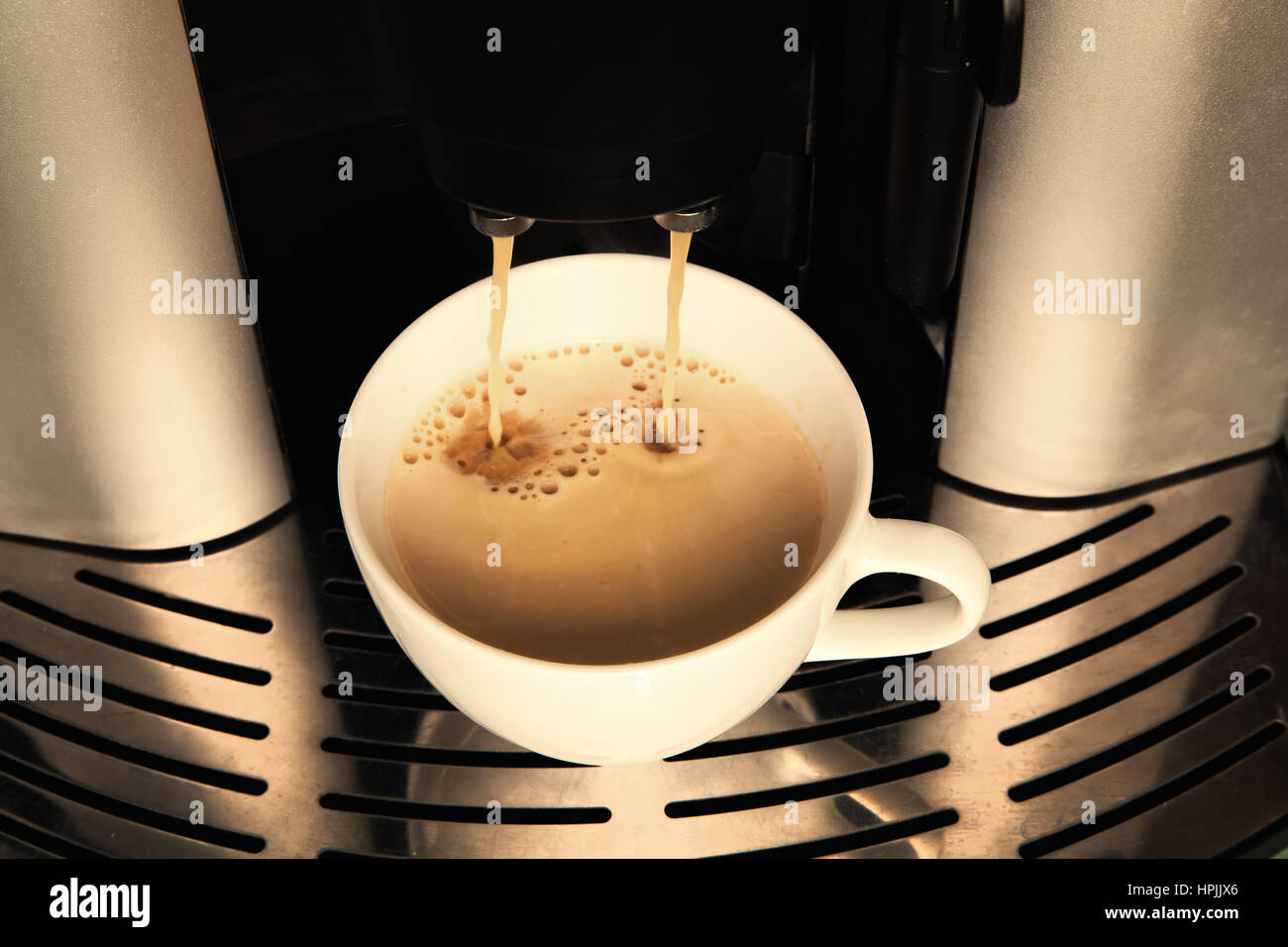 Coffee pouring from coffee machine into a white cup Stock Photo - Alamy