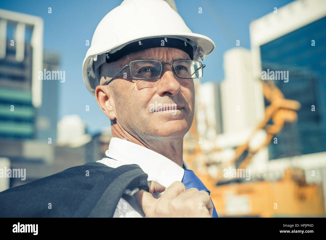 Senior elegant builder man in suit at construction site on sunny Stock ...