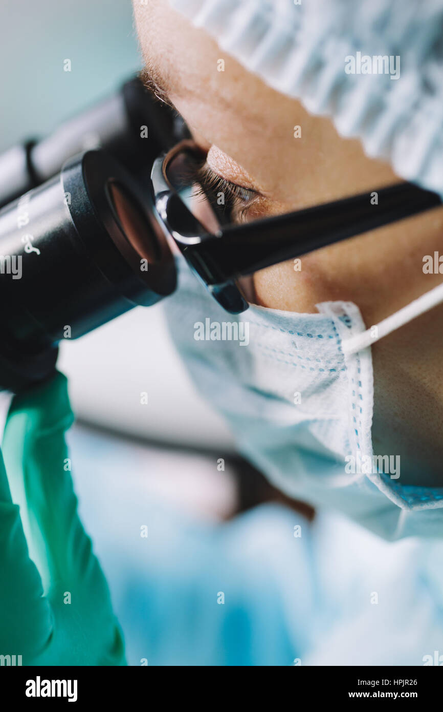 Close up view of scientist eye in glasses looking at microscope Stock ...