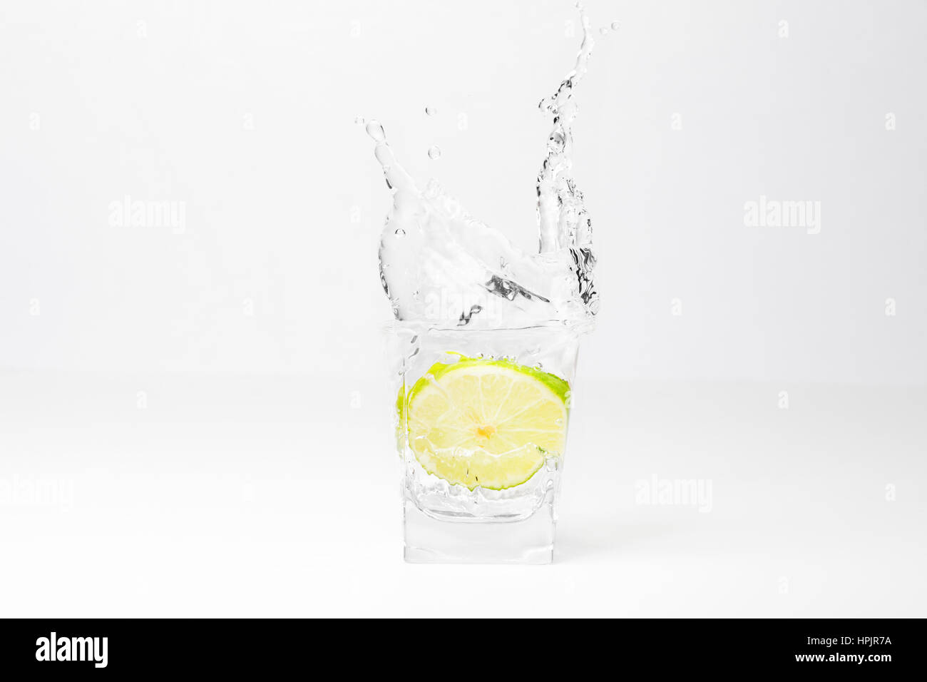 Lime is falling in the water on white background Stock Photo - Alamy