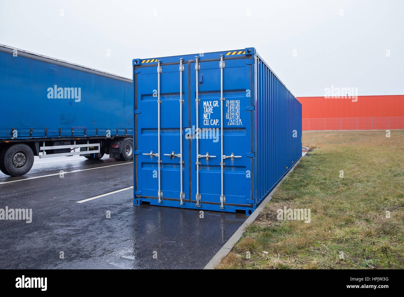 Blue transportation container and truck on parking Stock Photo - Alamy