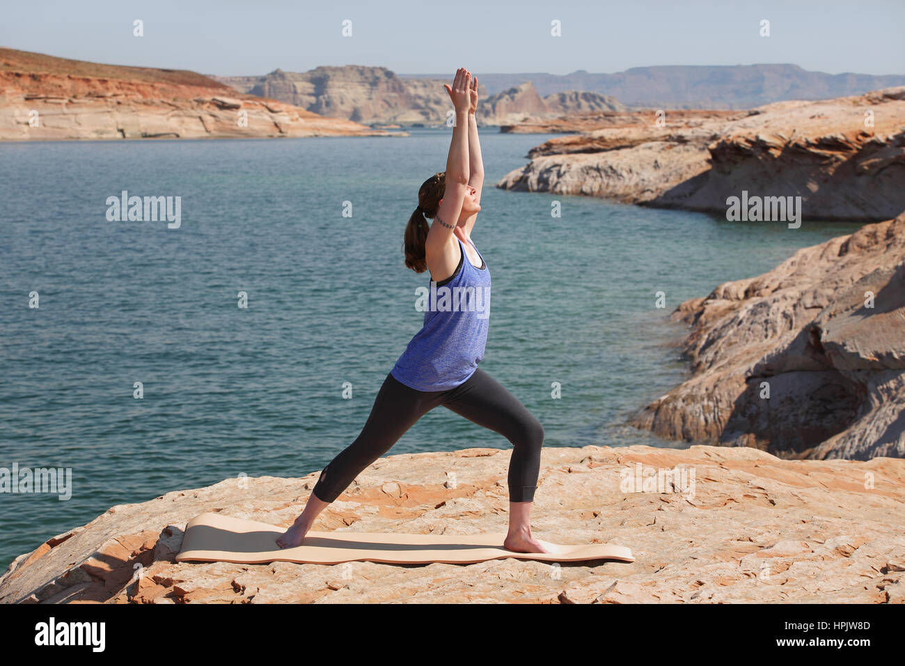 Woman practicing warrior yoga pose hi-res stock photography and images ...