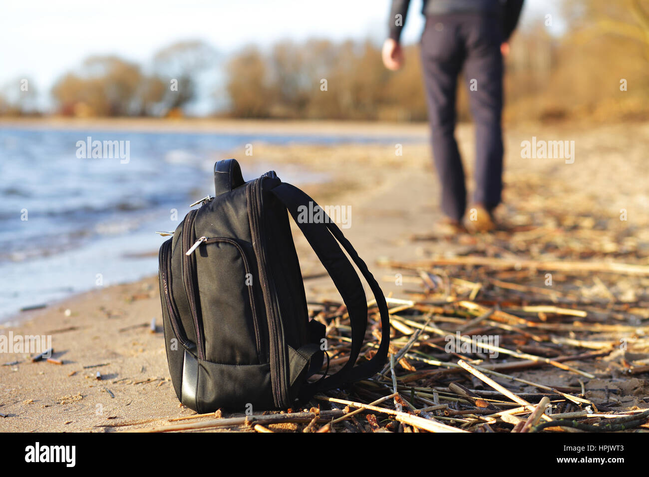 Man left his backpack and walking on the beach Stock Photo - Alamy