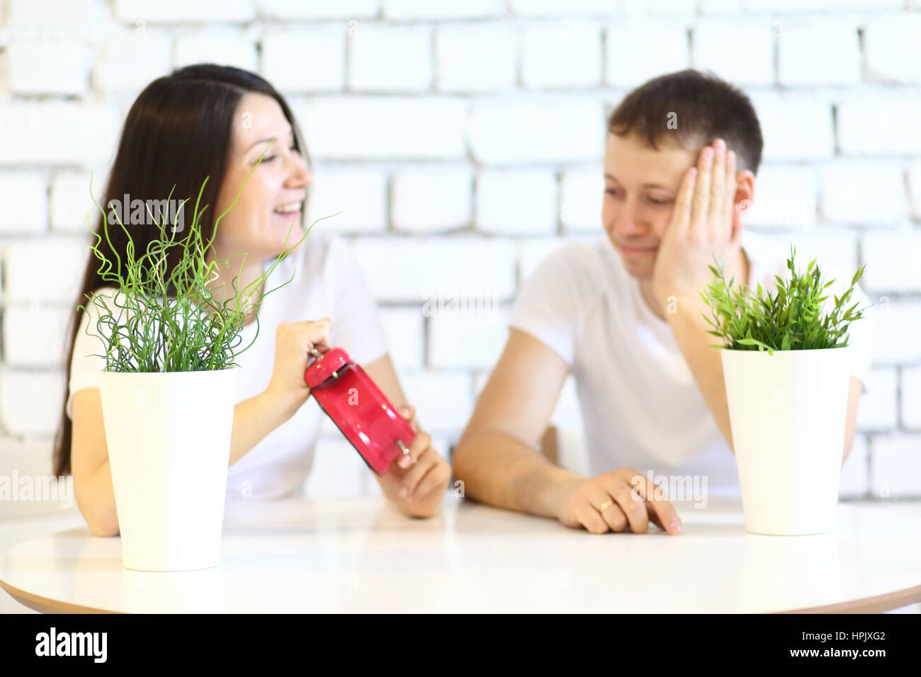 Young smiling couple waiting for happiness on white break wall ...