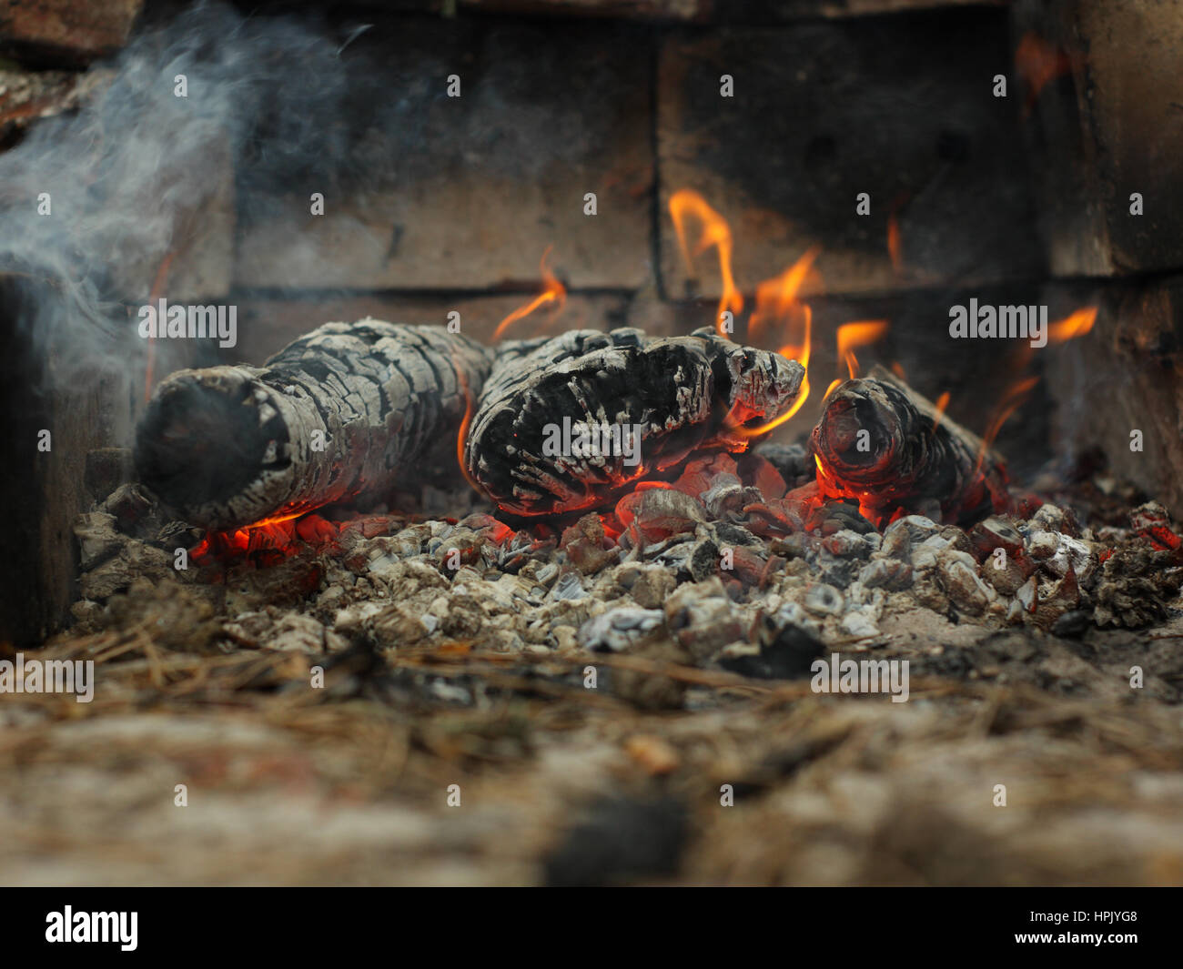 Embers and fire above firebrand in hearth, shallow DOF Stock Photo - Alamy