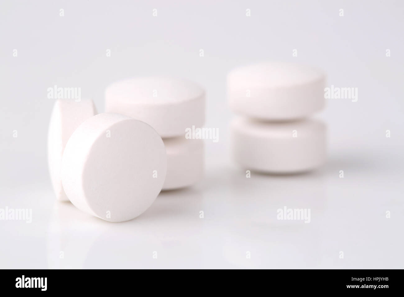 Closeup of round white pills sit on a table Stock Photo - Alamy
