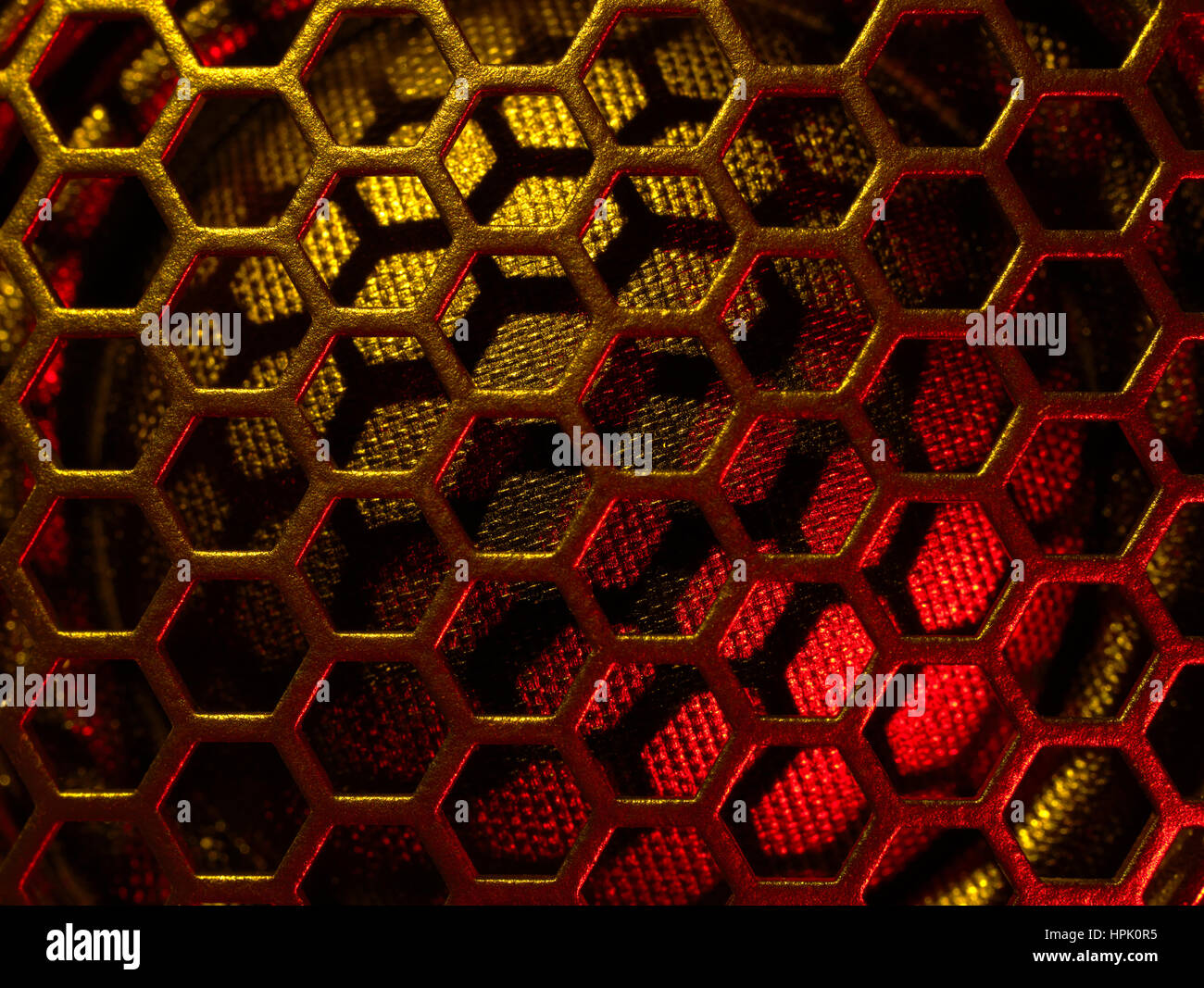 full frame colourful illuminated detail of a metallic grid in front of ...