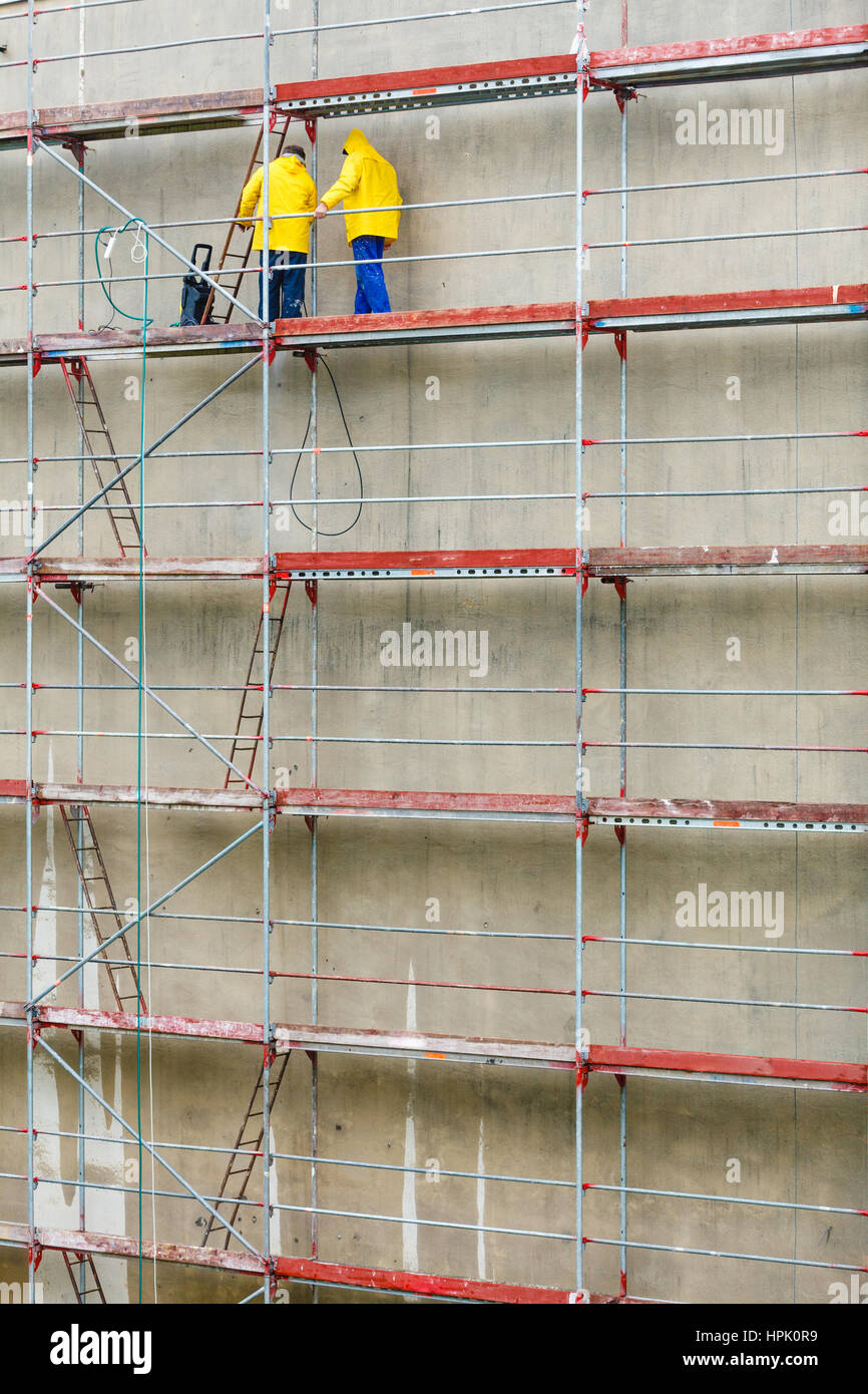 Men cleaning wall. Scaffolding, construction site in progress. Building ...