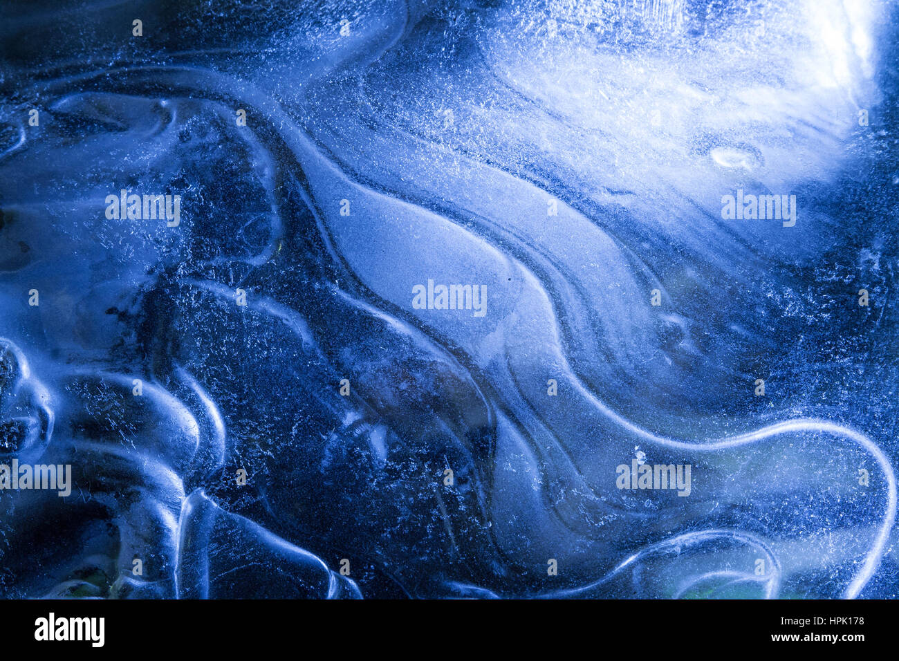 Network of cracks in thick solid frozen layer of ice with shining light ...