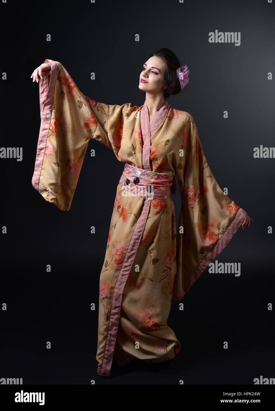 young dancing woman in traditional Japanese kimono on black background ...