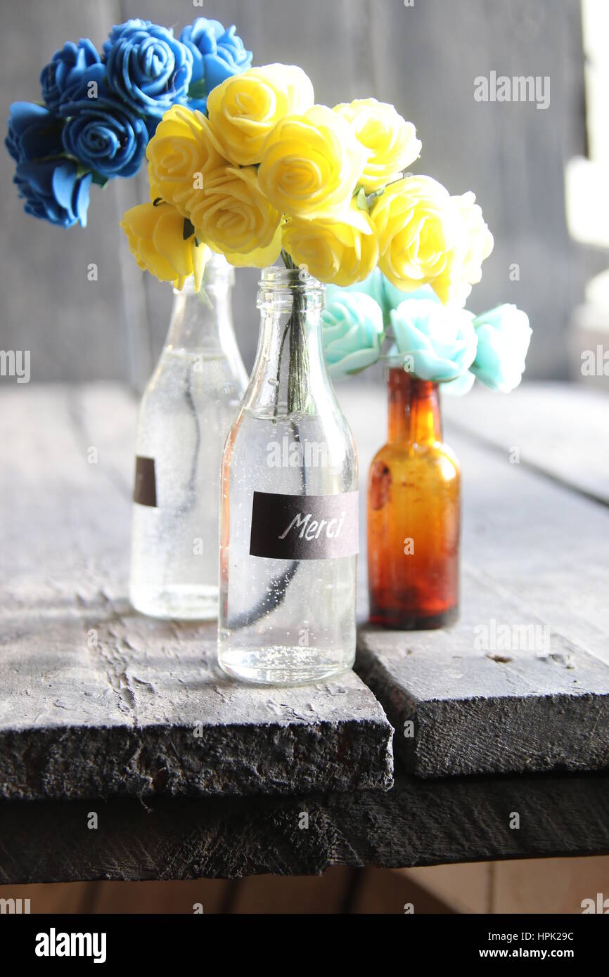 nice flowers in the bottles and label Merci, vintage style Stock Photo ...