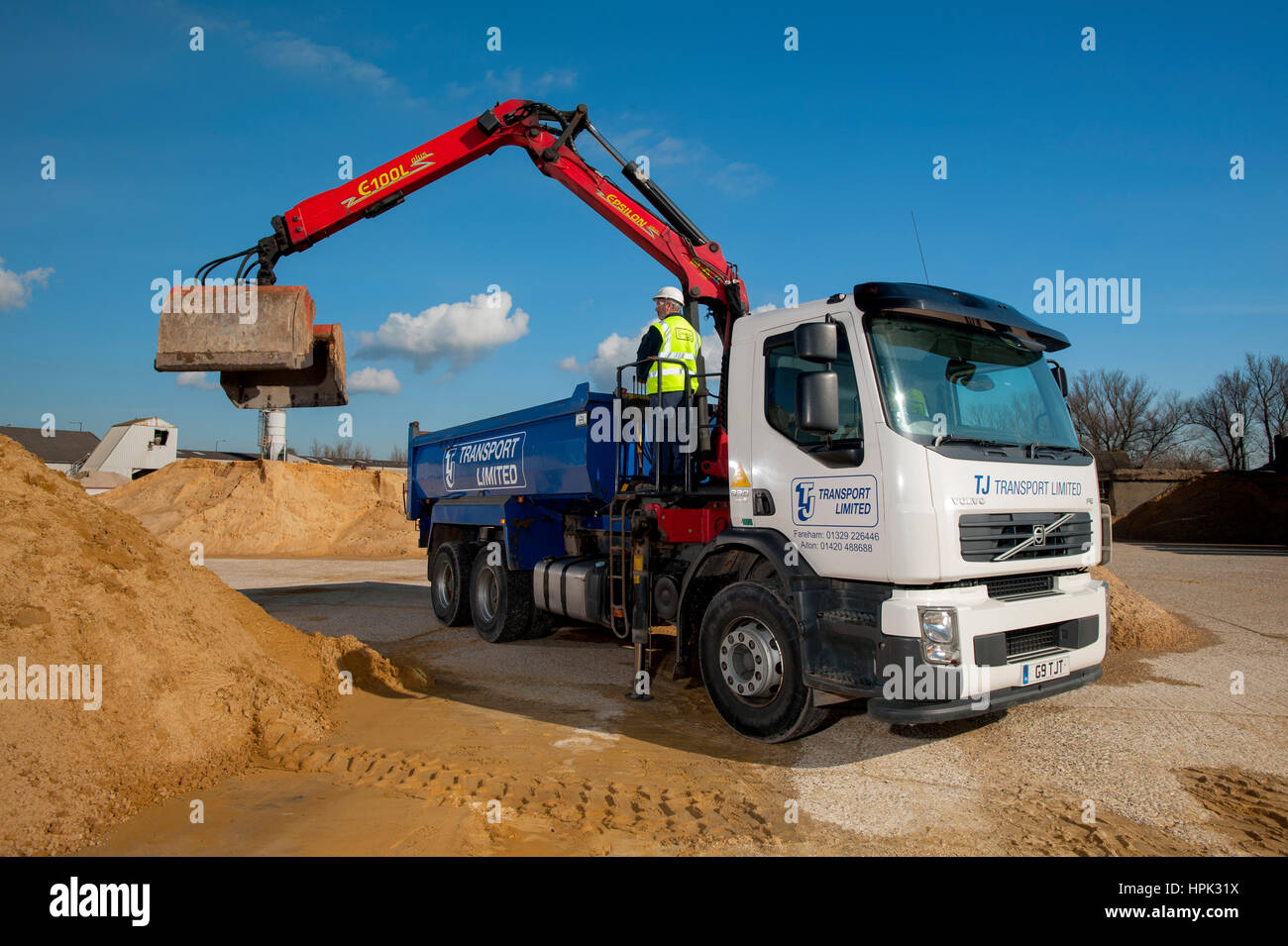 Grab tipper lorry picking up a load of aggregate Stock Photo - Alamy