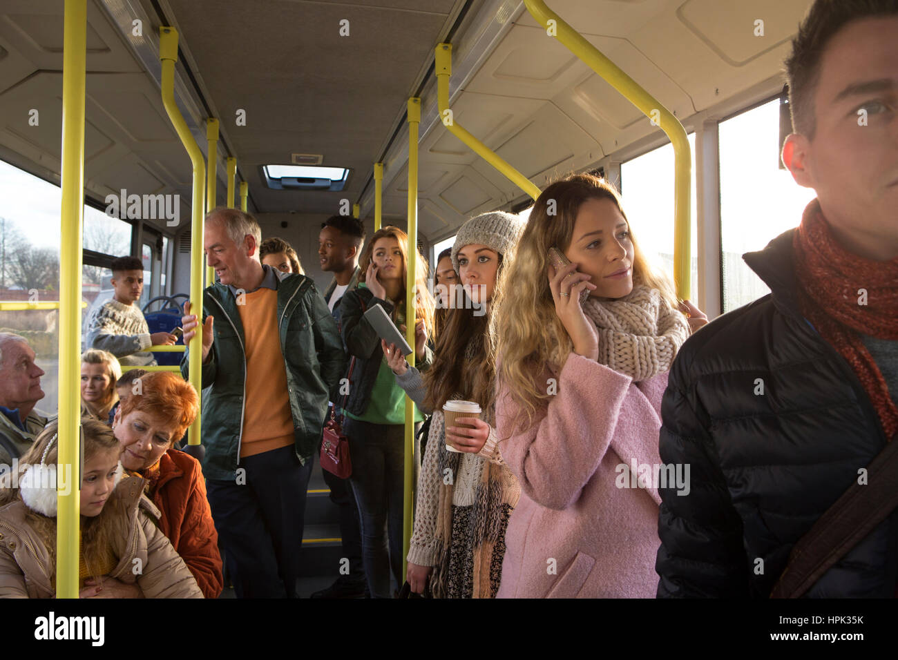 Different people can be seen travelling on the bus. Some are talking to ...