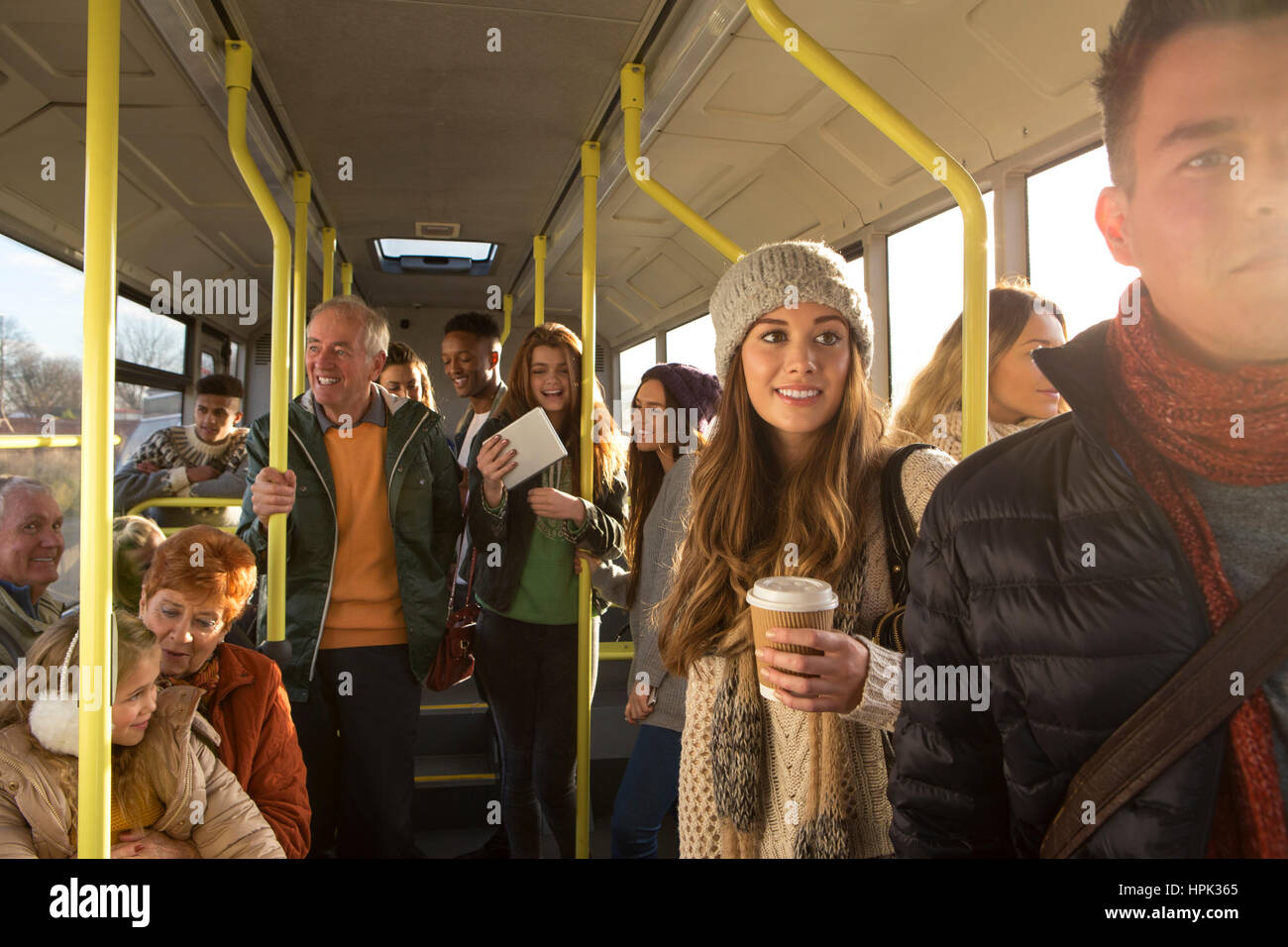 Different people can be seen travelling on the bus. Some are talking to ...