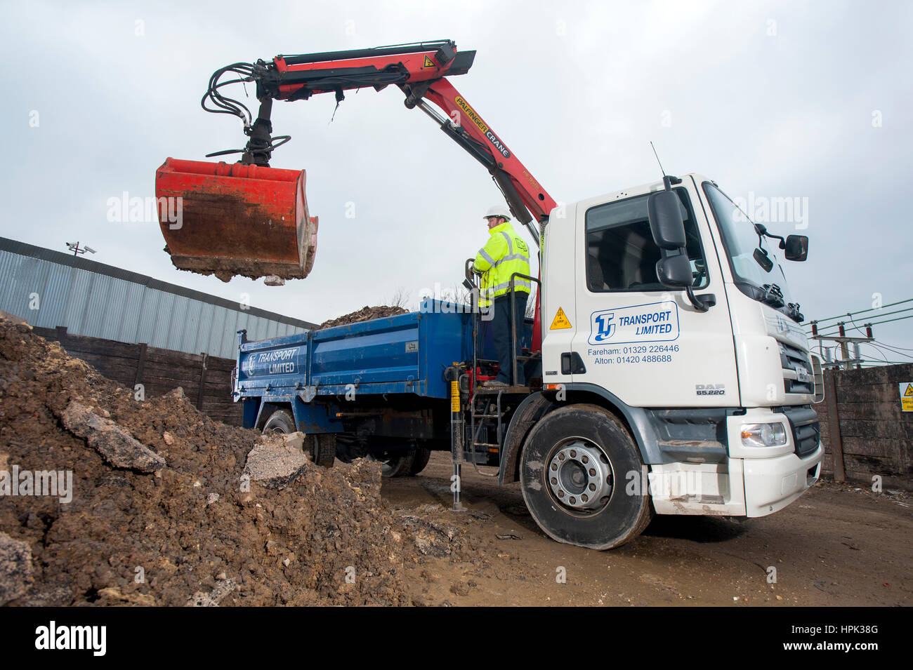 Grab tipper lorry picking up a load of aggregate Stock Photo - Alamy