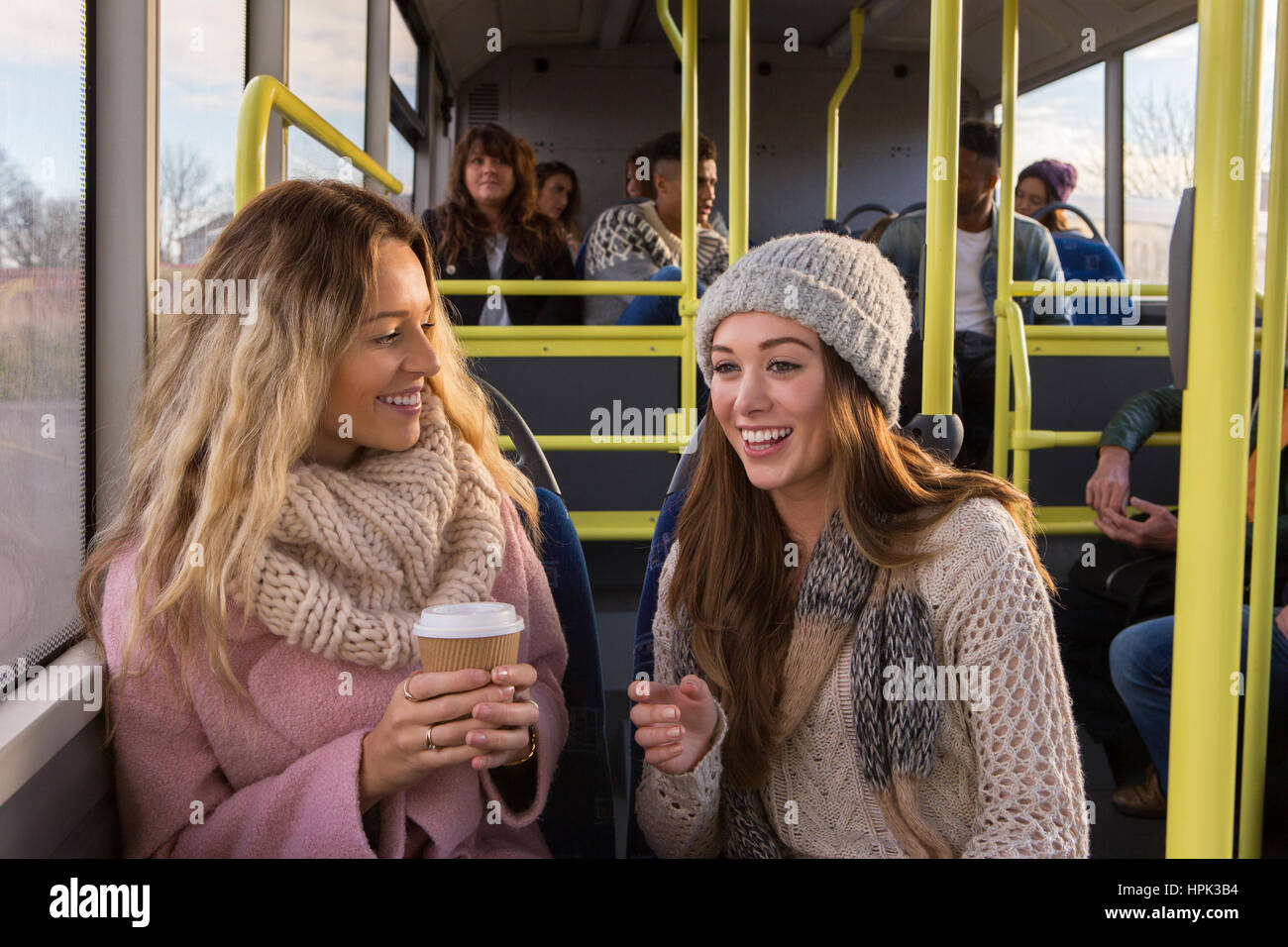 Two women talking as they travel on a bus together Stock Photo - Alamy