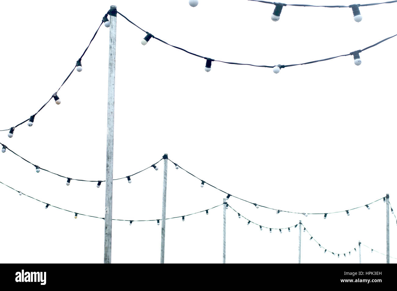 String of light bulbs on metal poles on grey day Stock Photo - Alamy