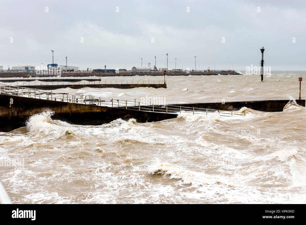 Sea front battered by rough seas during storm. Concrete and wooden ...