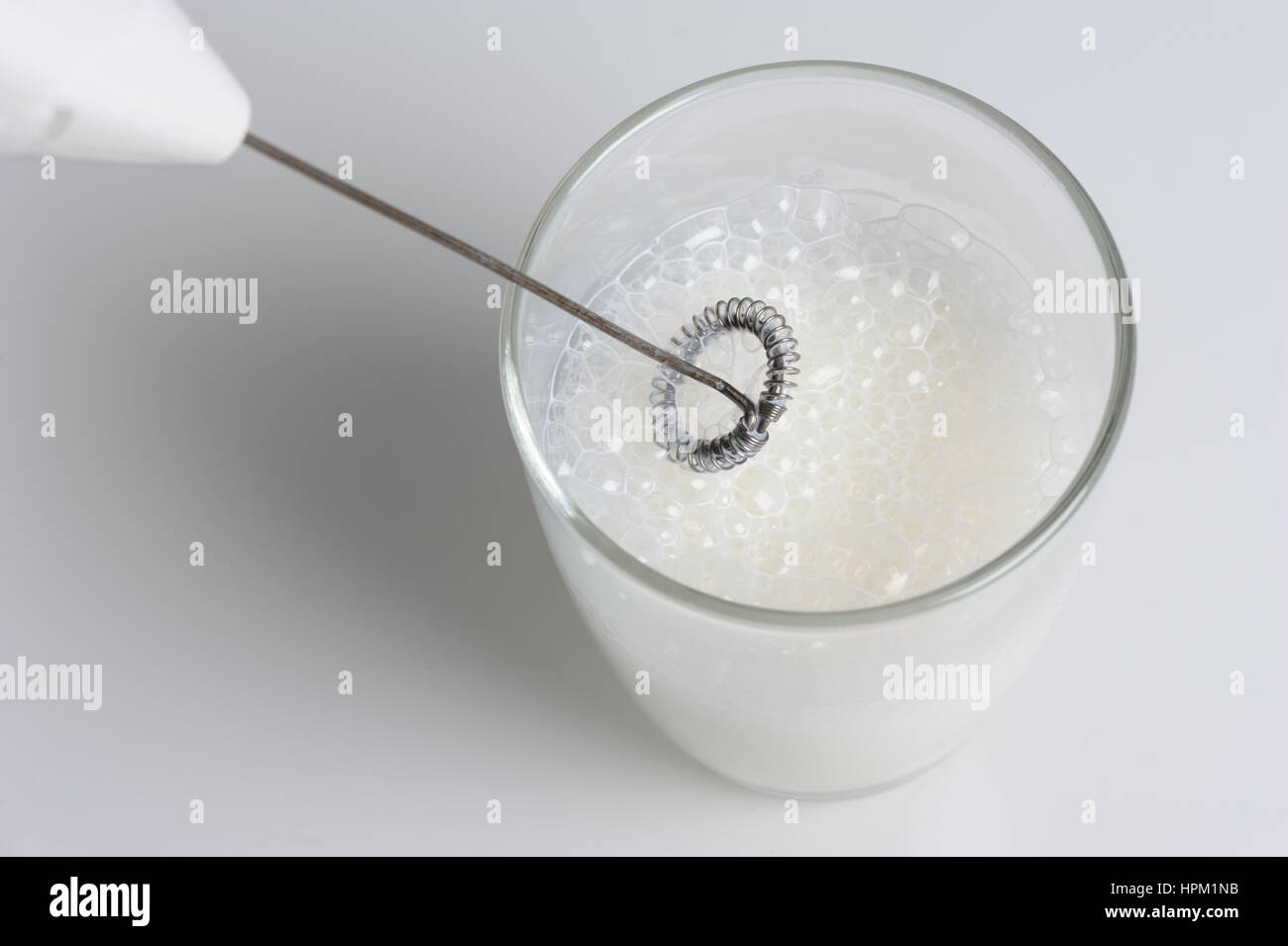 making foamy milk with milk frother, home cooking Stock Photo - Alamy