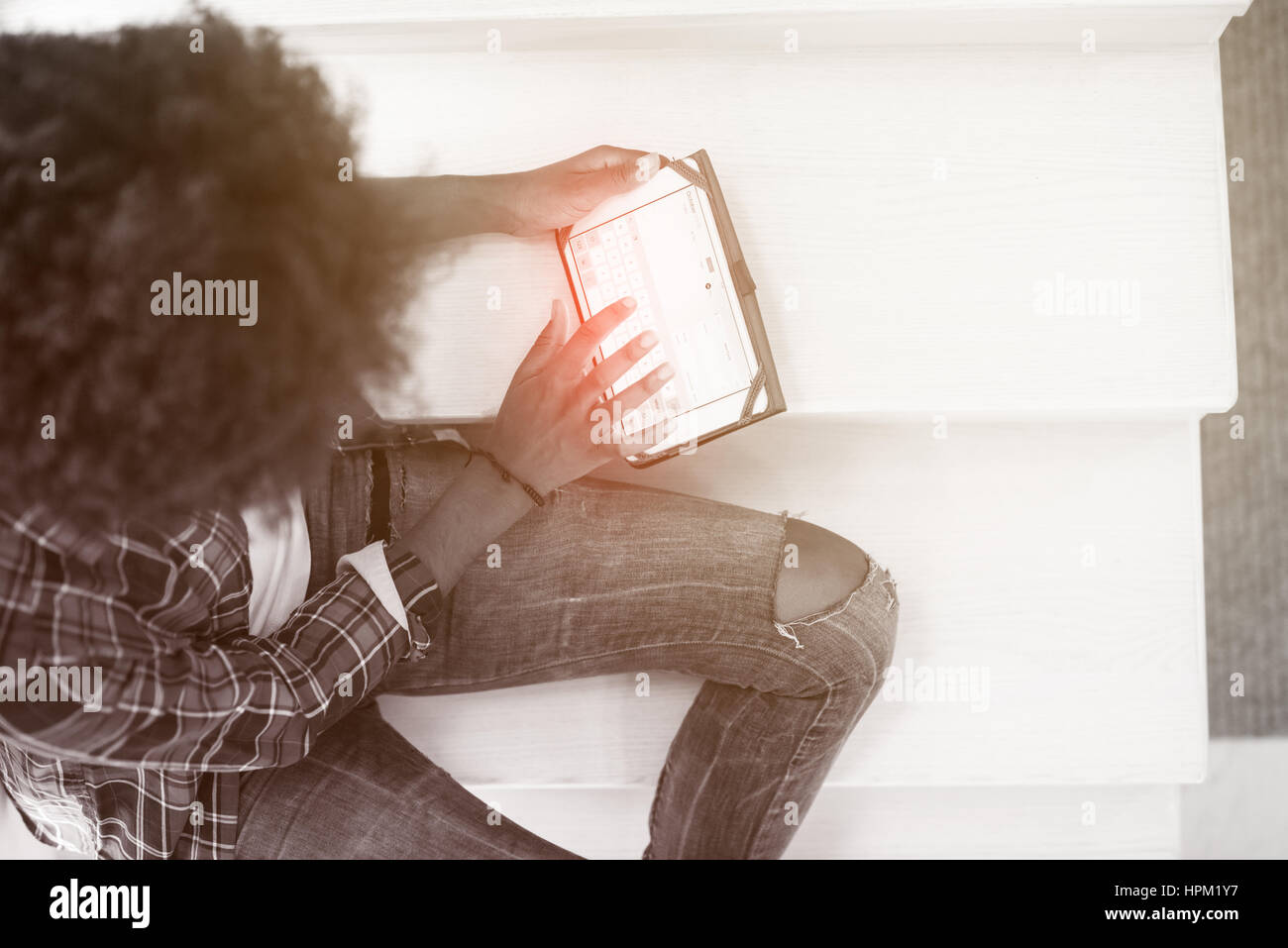 Attractive young black woman using her electronic tablet while sitting ...