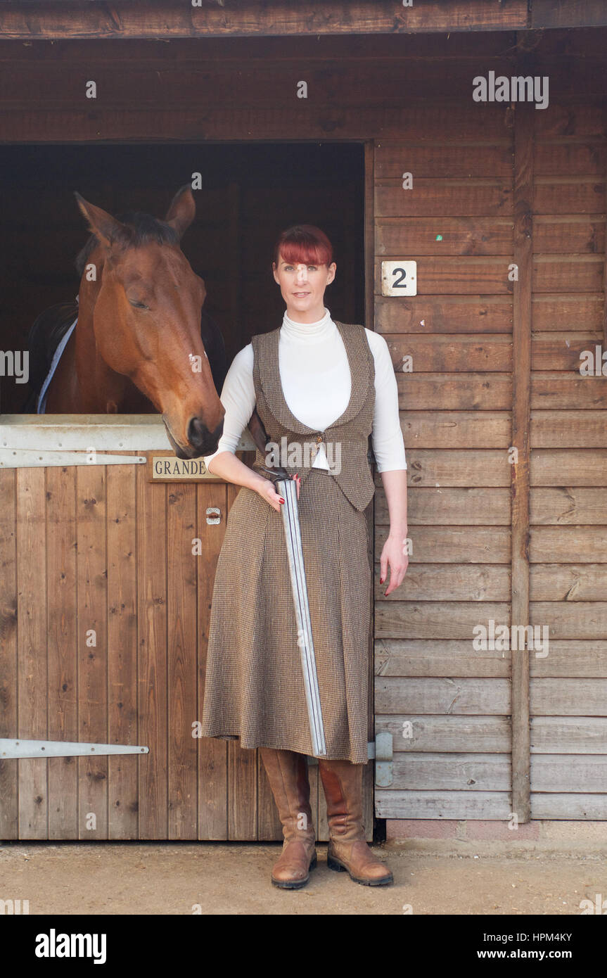 Beautiful woman in gamekeepers tweed suit at a stable with a vintage ...