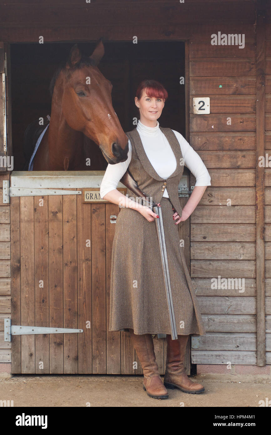 Beautiful woman in gamekeepers tweed suit at a stable with a vintage ...