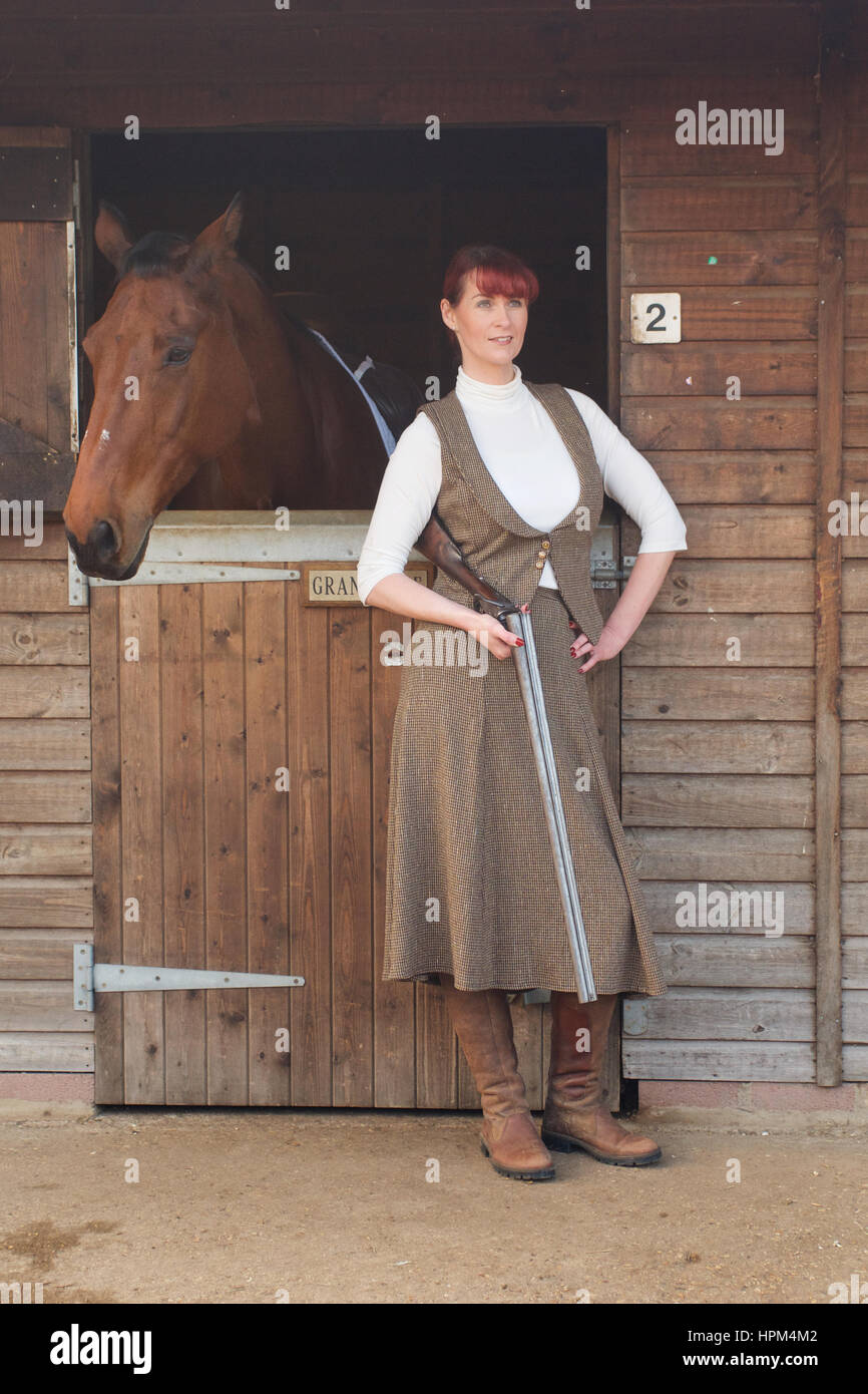 Beautiful woman in gamekeepers tweed suit at a stable with a vintage ...